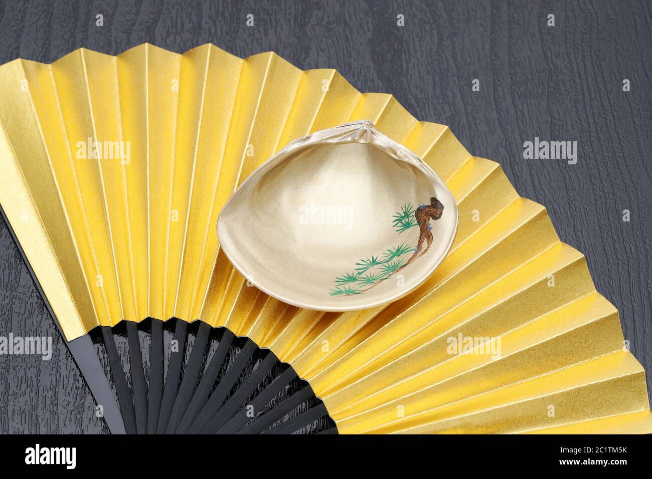Japanese golden folding fan and gold painting seashell on black ...