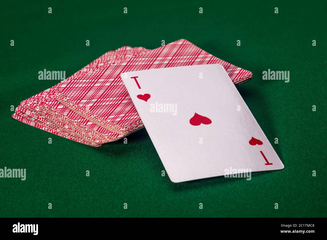 playing card ACE on an inverted deck of cards on a green table Stock ...