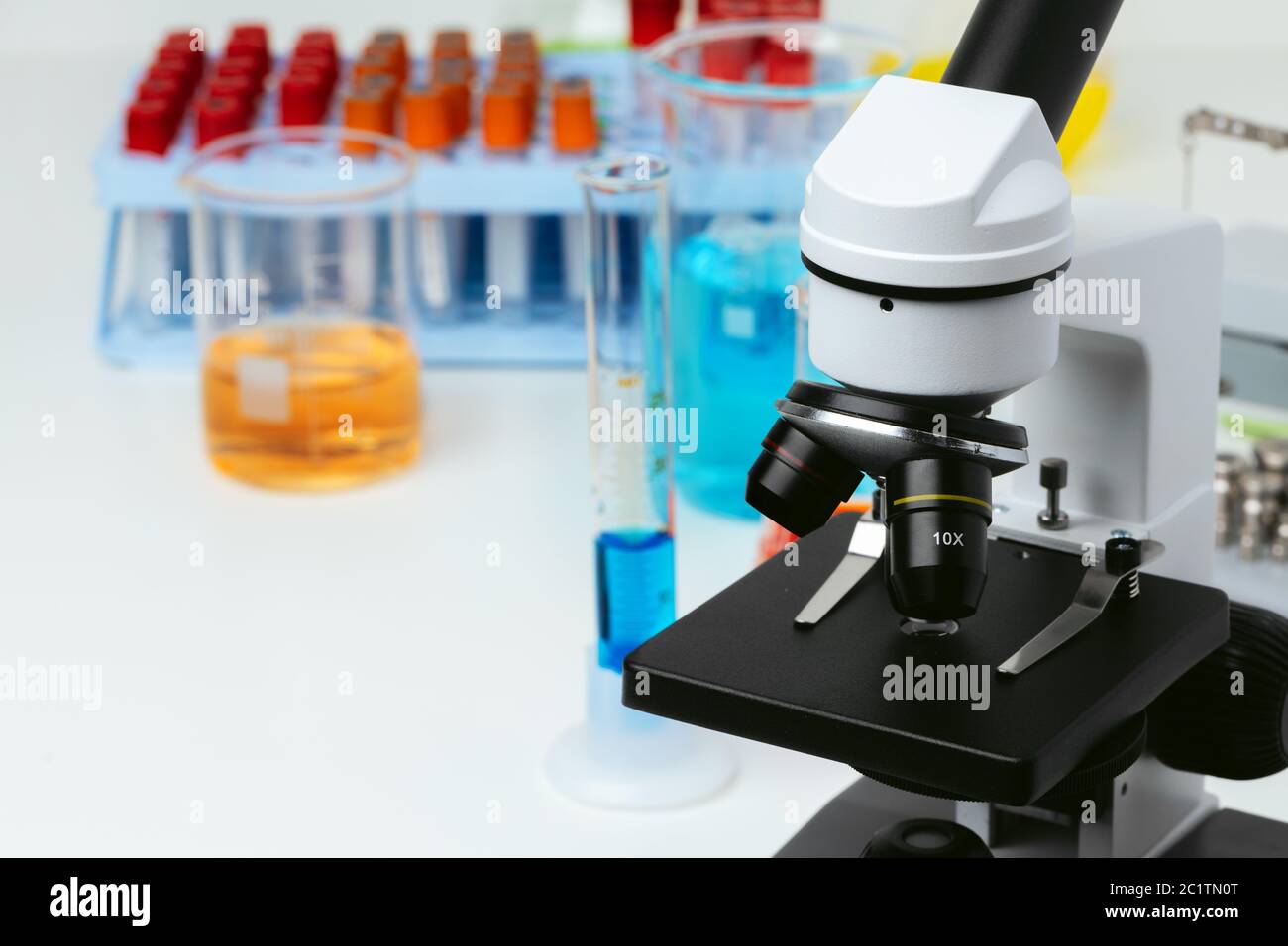 Microscope and test tubes on table in laboratory, close up Stock Photo ...
