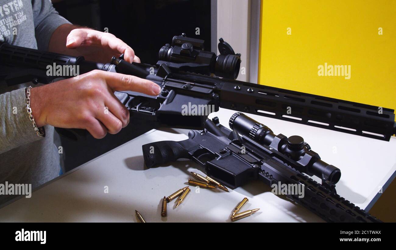 Shooting instructor loading an assault rifle at a shooting range. High ...