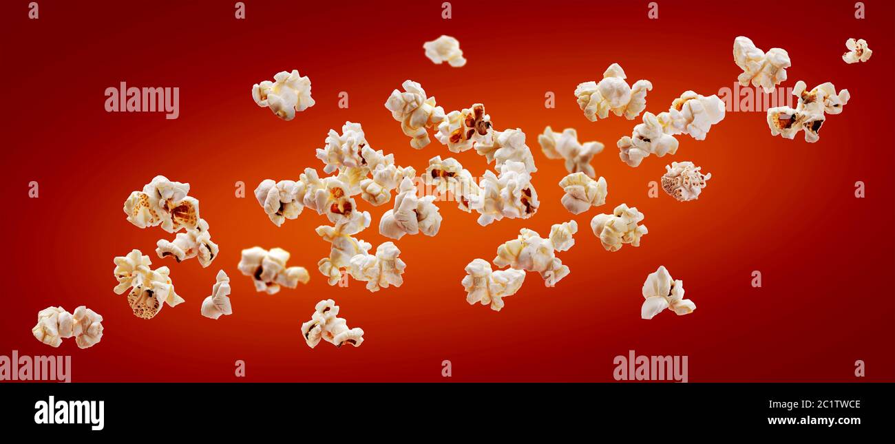 Popcorn isolated on red background. Falling or flying popcorn. Close-up ...