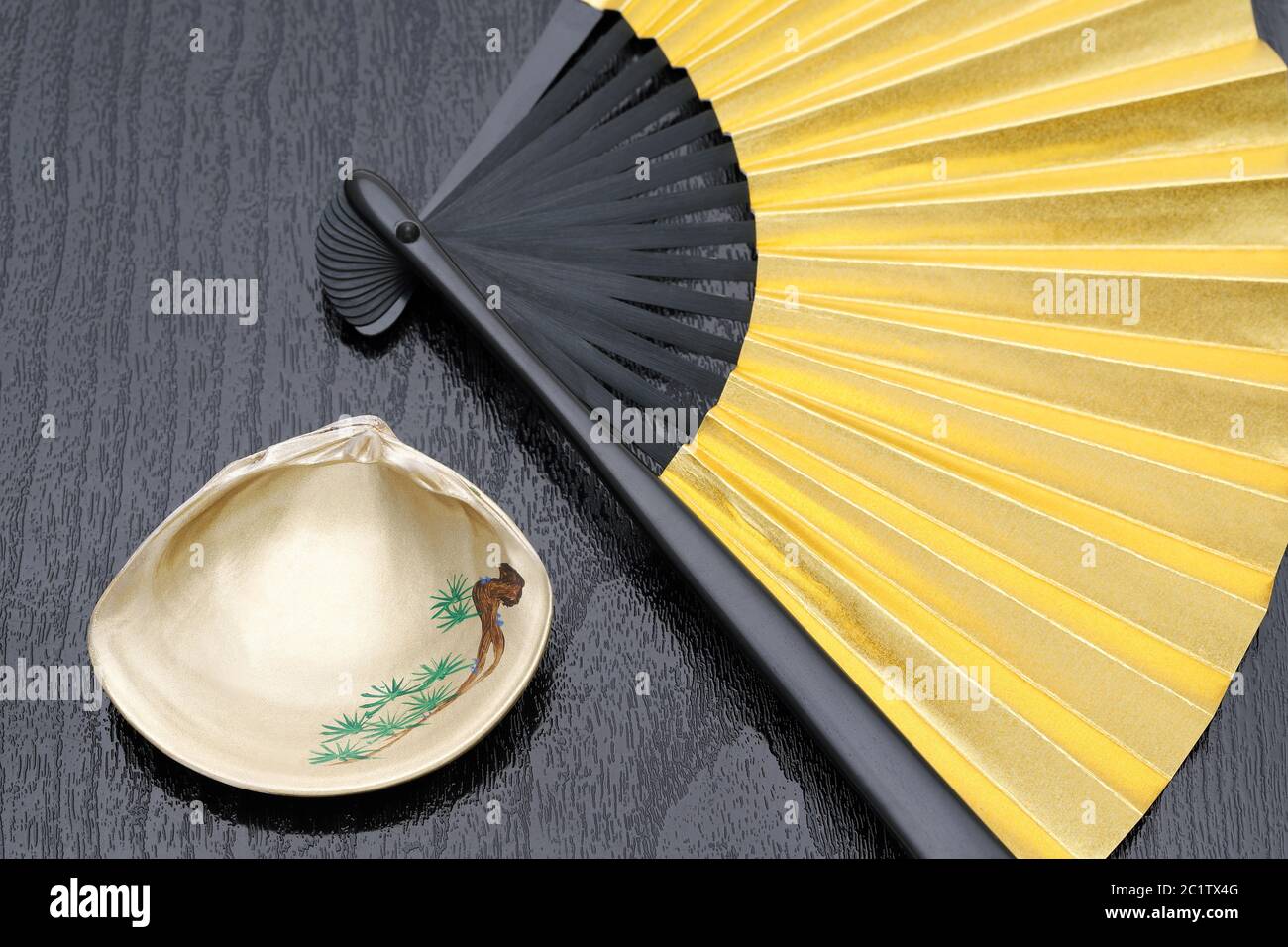 Japanese golden folding fan and gold painting seashell on black ...