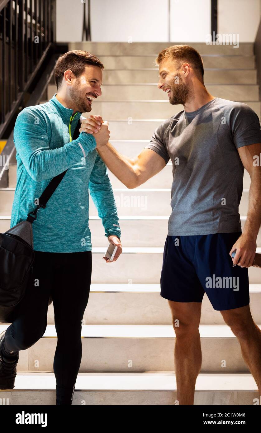 Handsome fit men friends talking, smiling after workout in gym Stock ...