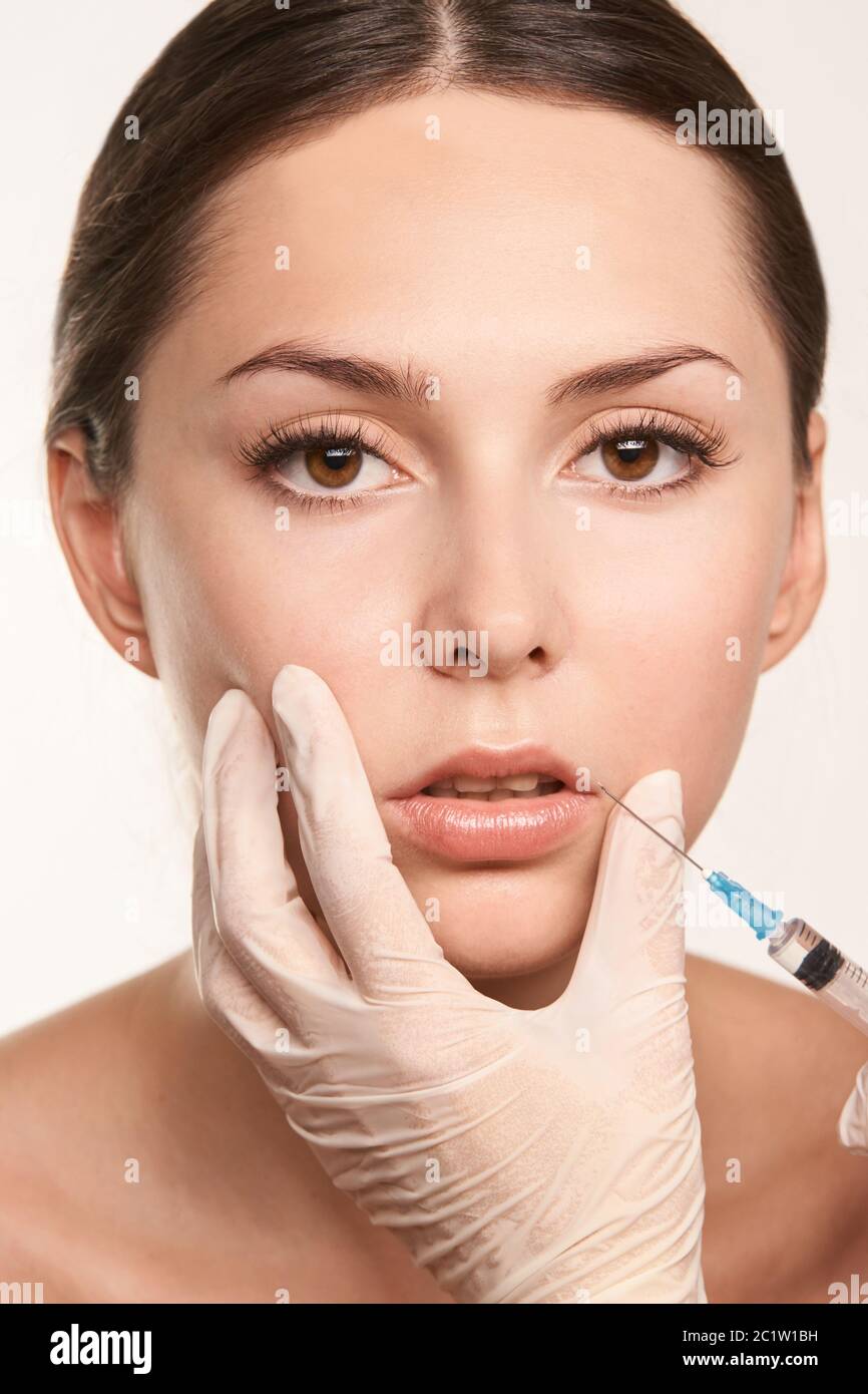 lip augmentation injection. Young woman. Doctor hand. Medical process ...