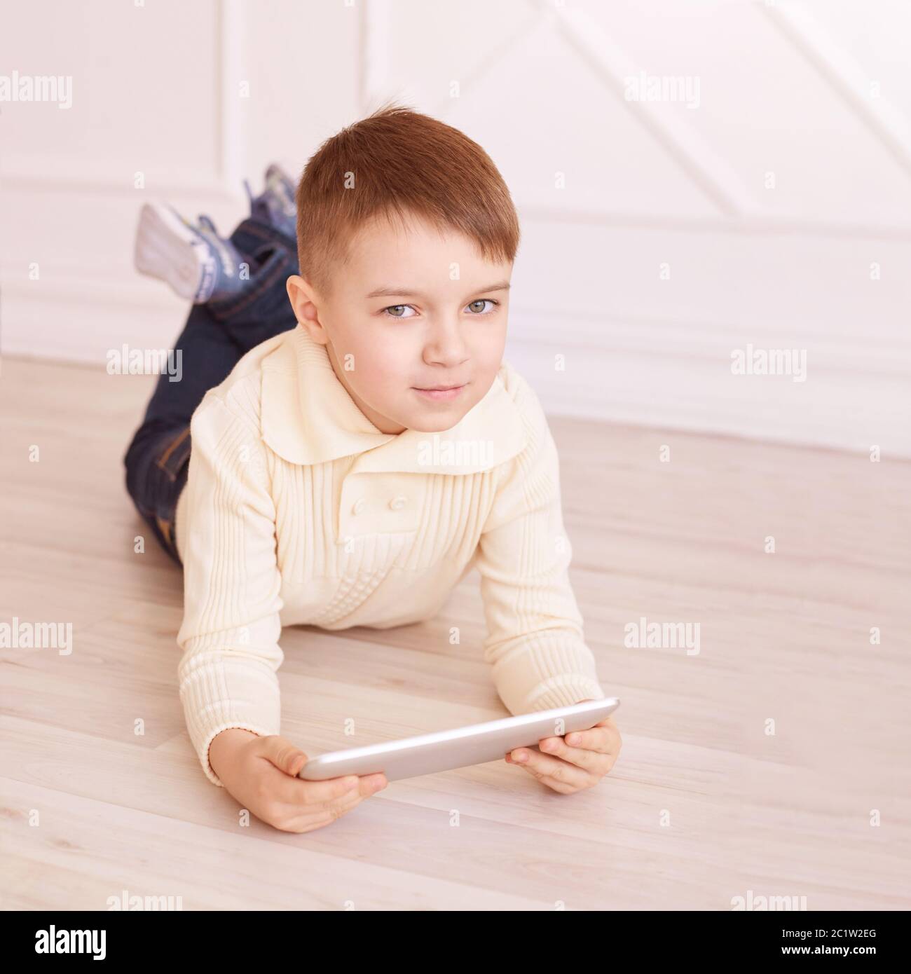 Cute boy. Computer tablet. play game, chat. Training. light interior ...
