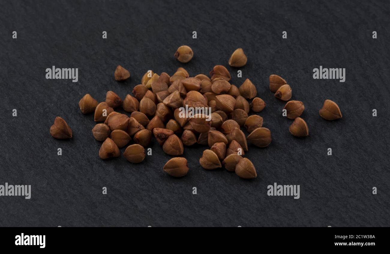 Buckwheat grains on black background Stock Photo - Alamy