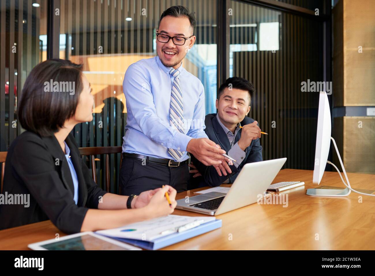 Professional business analyst demonstrating stats to colleagues on ...