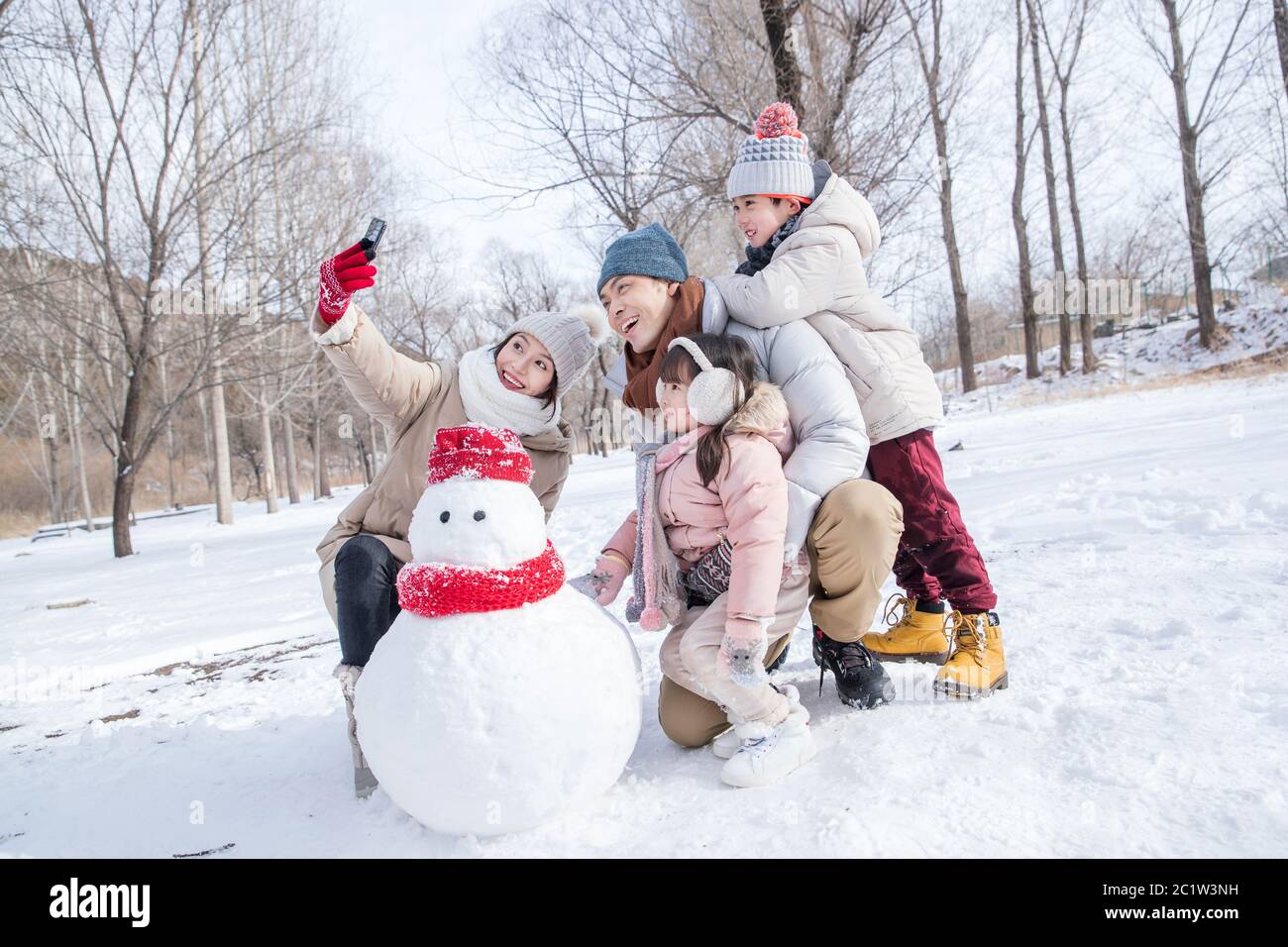 Happy family make a snowman in the snow Stock Photo - Alamy
