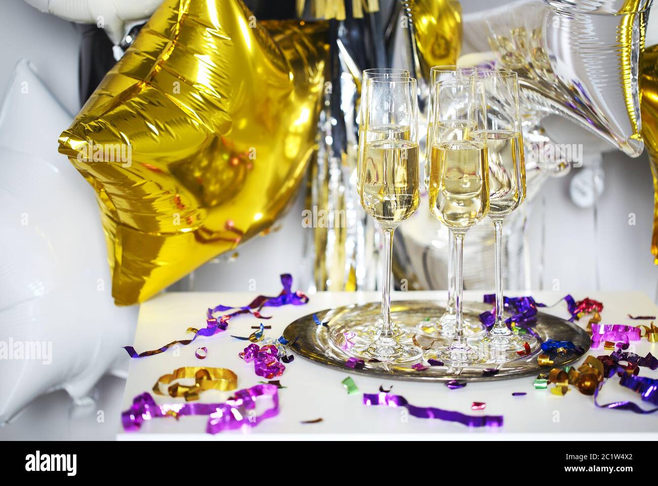 Close up of shiny glasses of champagne over black, white, golden and ...