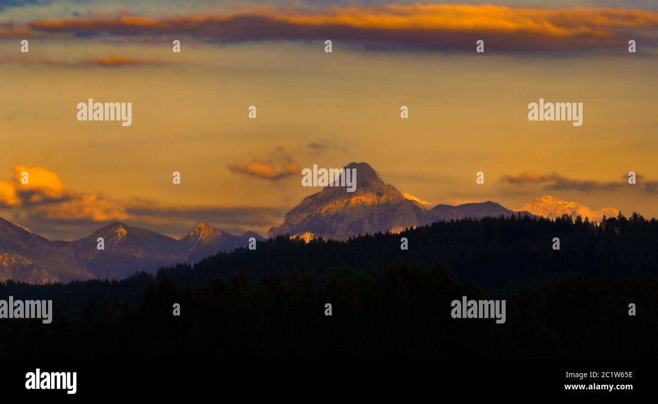 The setting sun illuminates the mountain Stock Photo - Alamy