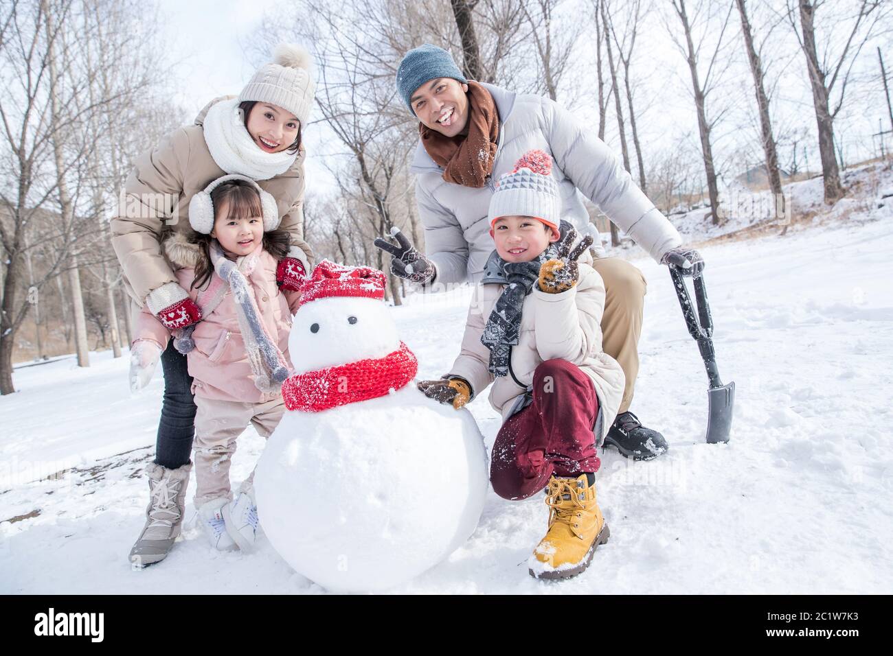 Happy family make a snowman in the snow Stock Photo - Alamy