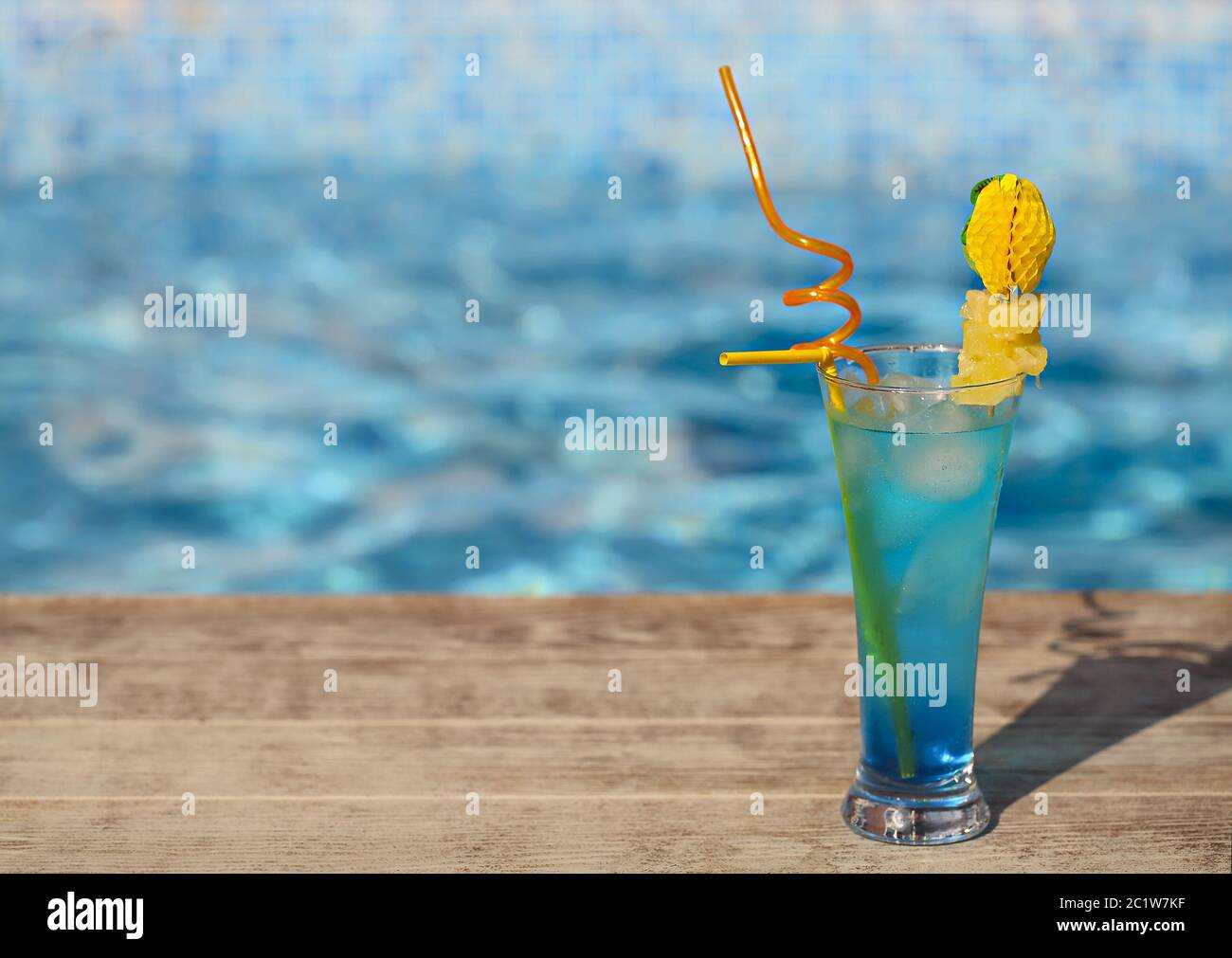 Glass with a bright blue lagoon cocktail on the table by the pool Stock ...