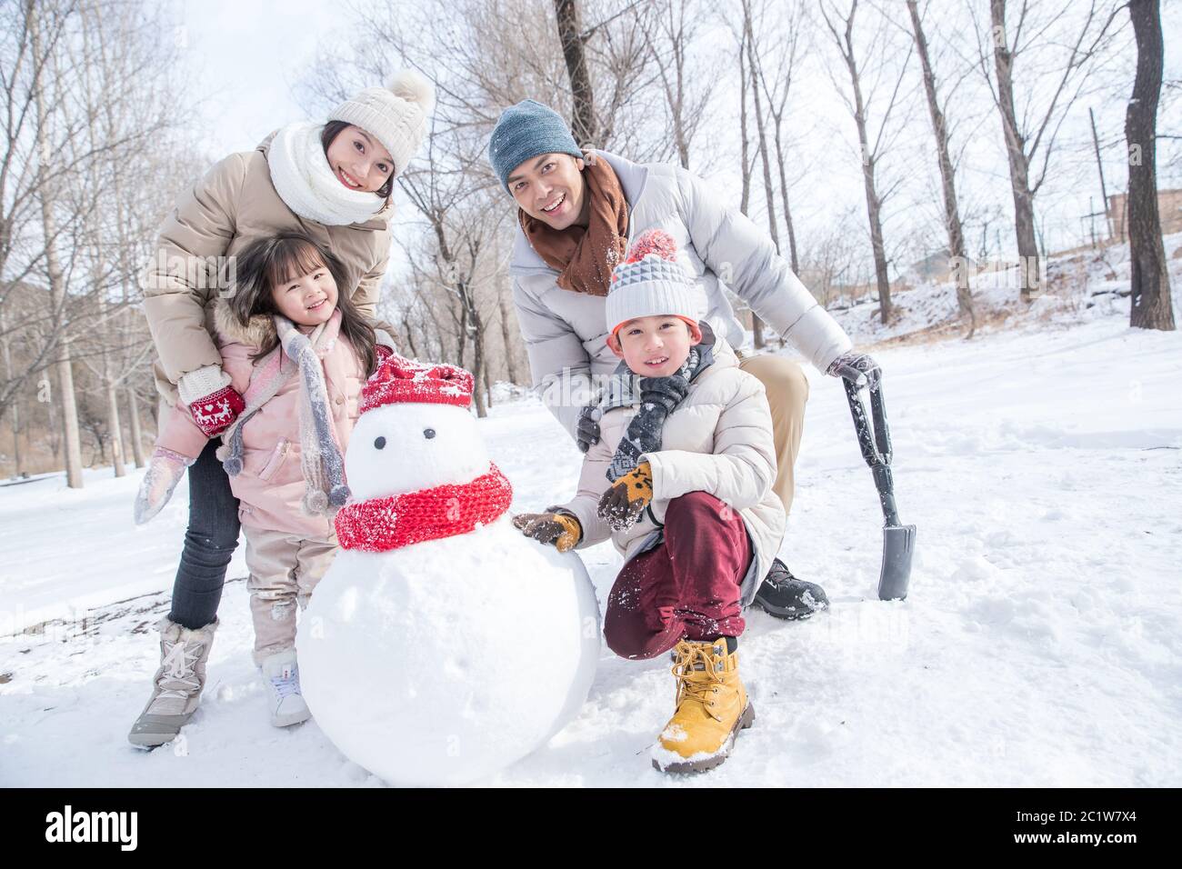 Happy family make a snowman in the snow Stock Photo - Alamy