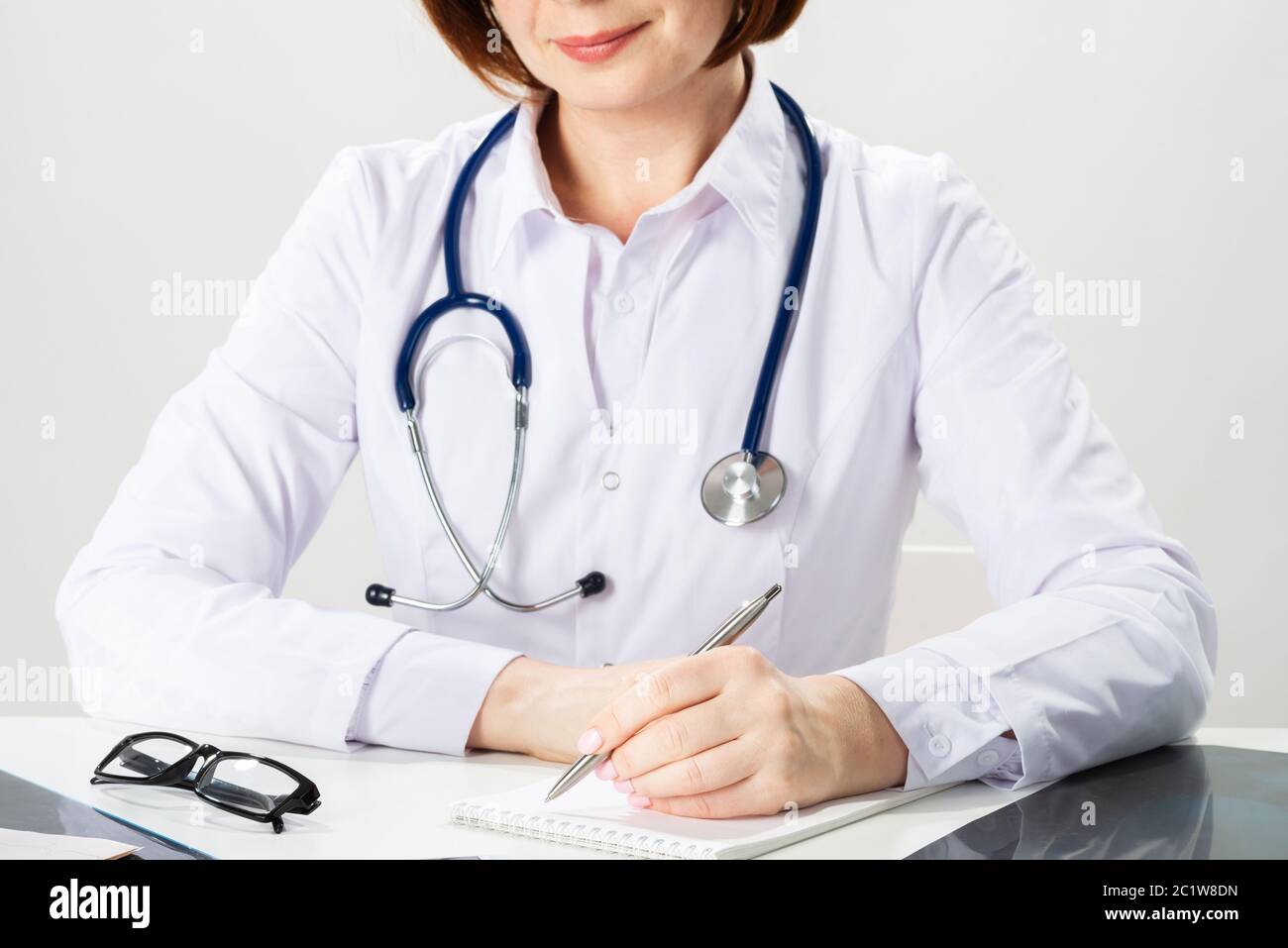 Close up female doctor hands writing on paper Stock Photo - Alamy