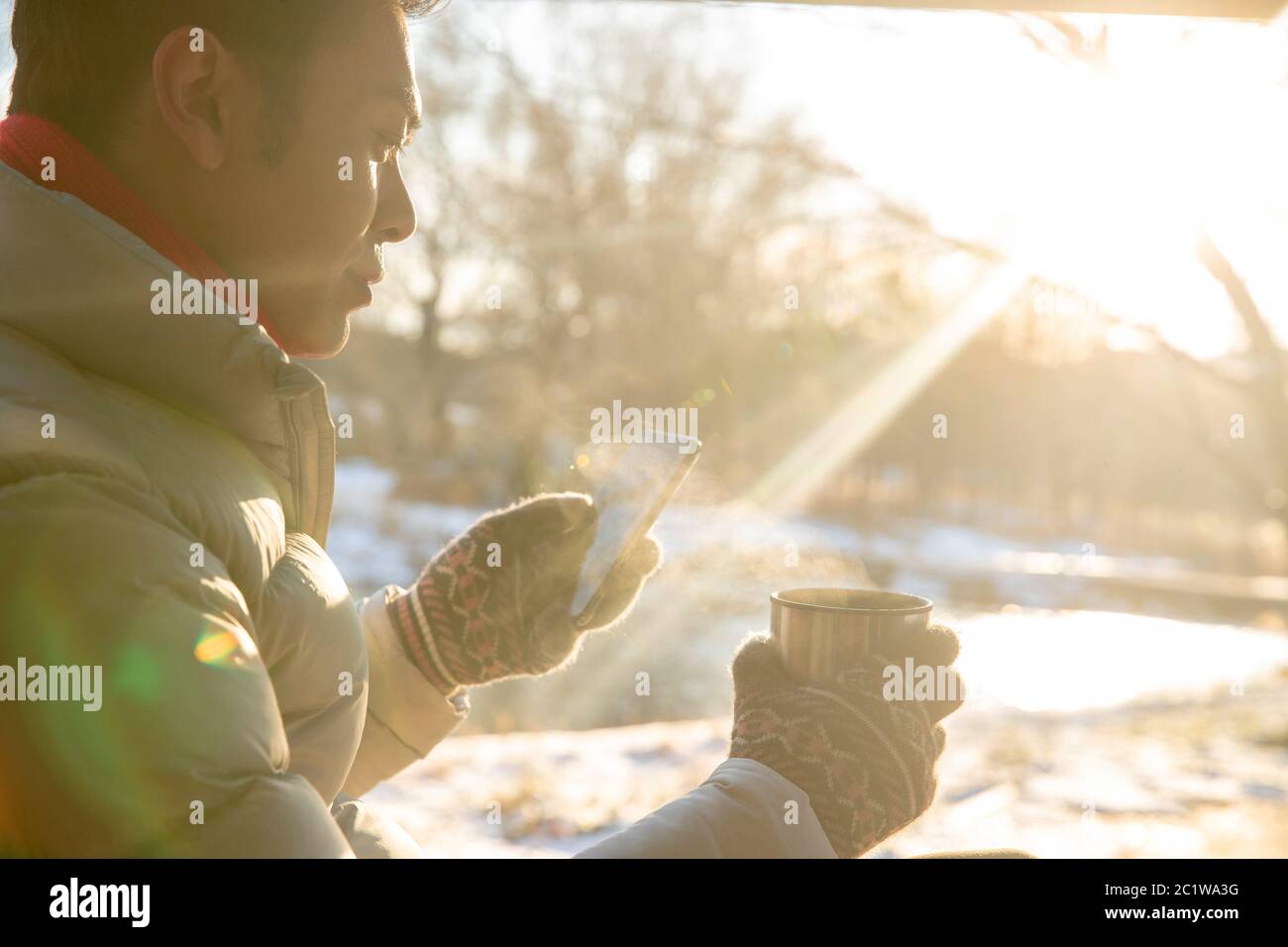 The man sitting in the snow to see mobile phone Stock Photo - Alamy