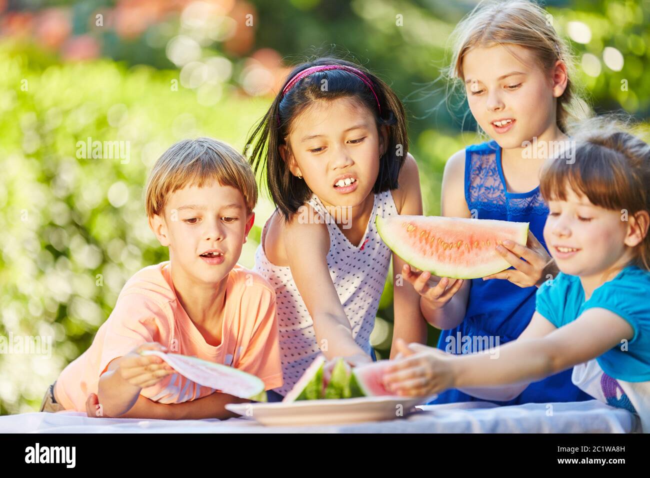 Many children eat melon together as fruit in summer Stock Photo - Alamy