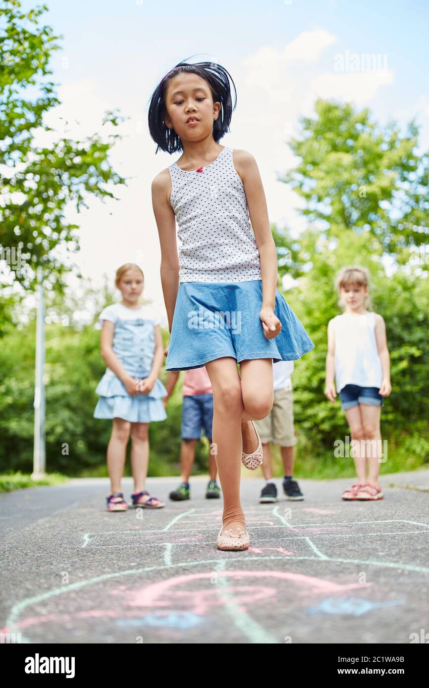 Children play a hopping game together in summer in kindergarten Stock ...