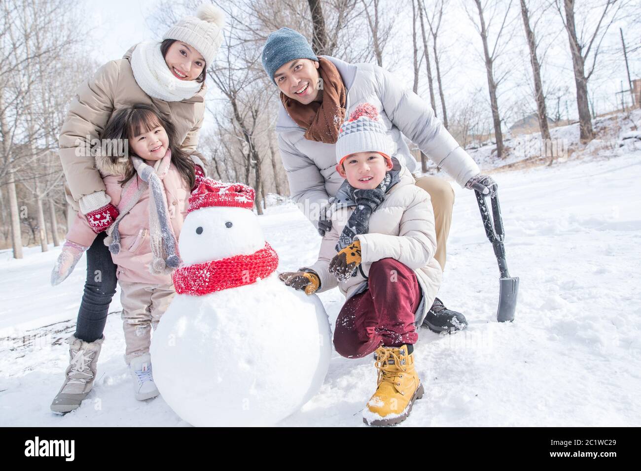 Happy family make a snowman in the snow Stock Photo - Alamy