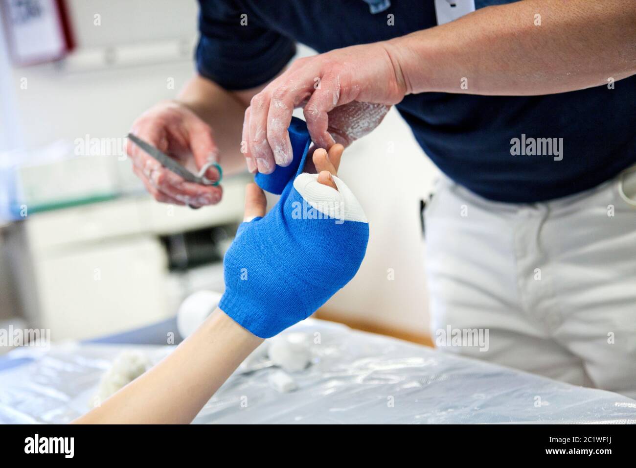 doctor bandaging plaster cast to kids broken hand bone in hospital ...