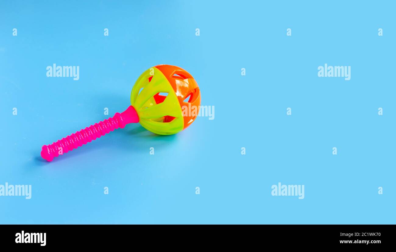 Colorful baby rattle on blue background. Copy space Stock Photo - Alamy