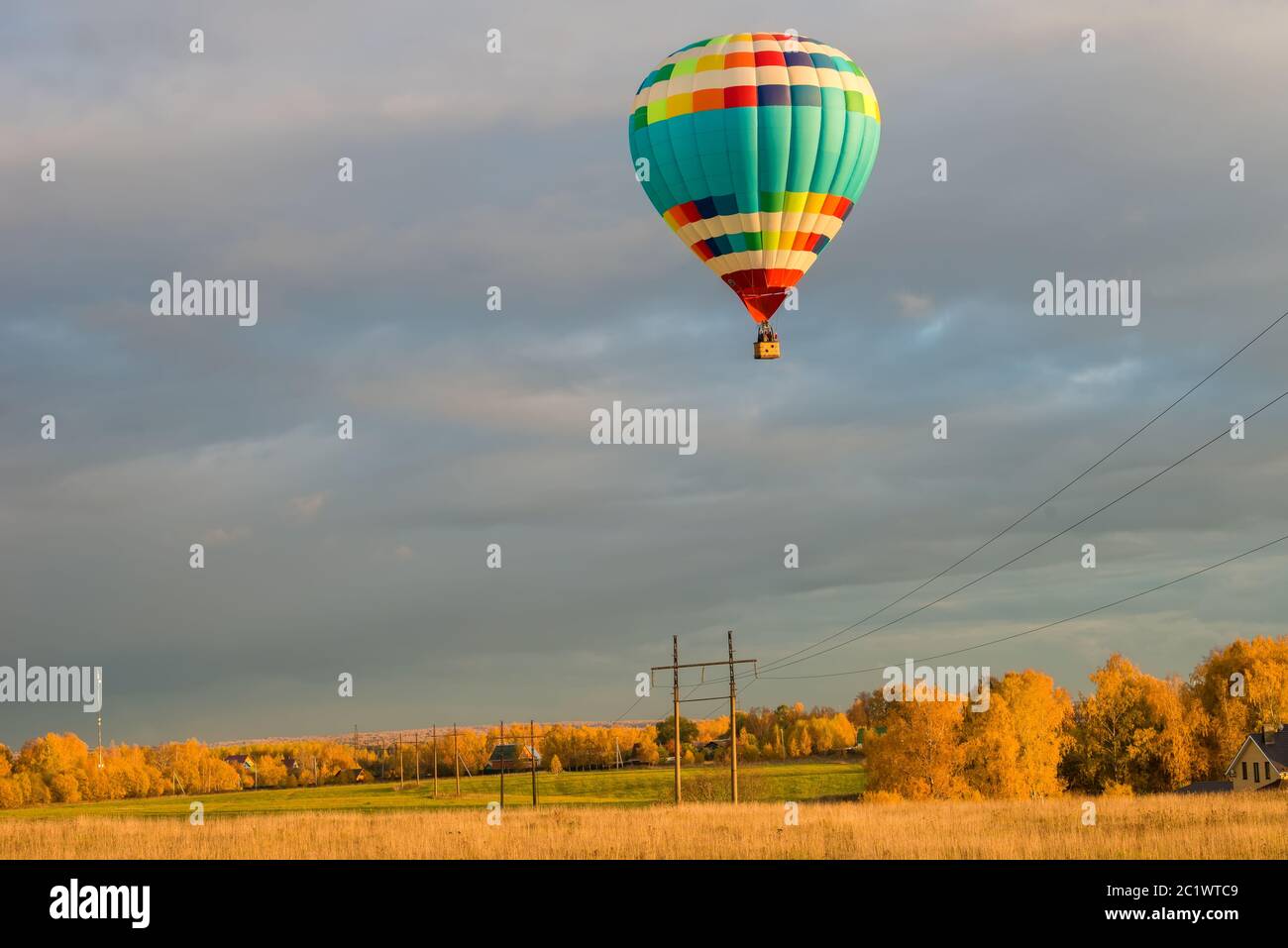 Colorful big hot air balloon flying against the cloudy sky in the ...