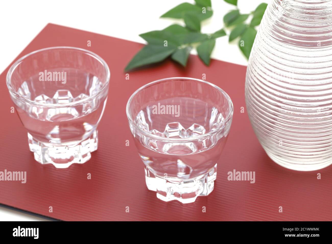 Japanese sake in transparent glass cup and jar on white background ...