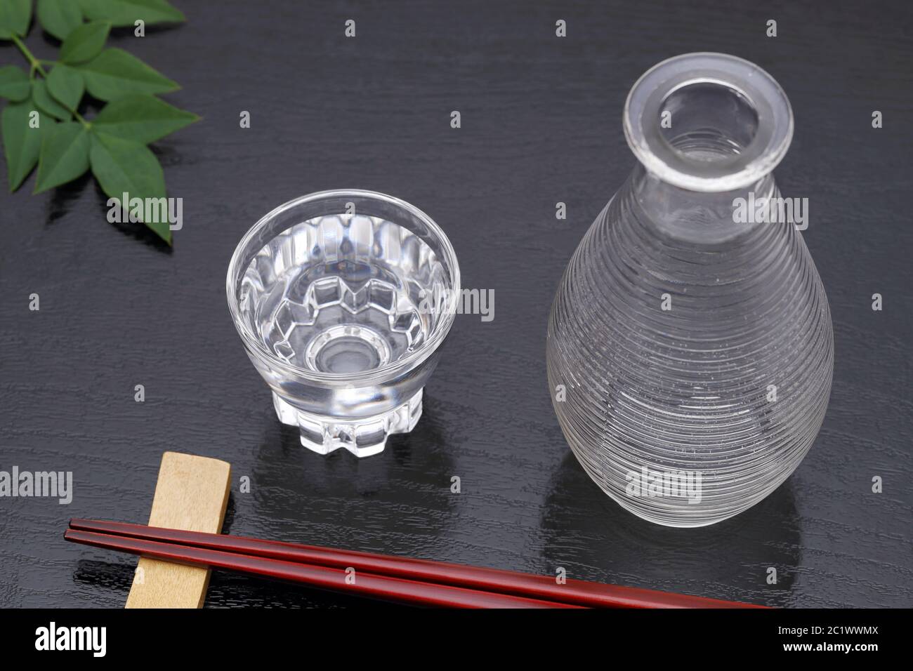 Japanese sake in transparent glass cup and jar on black background ...
