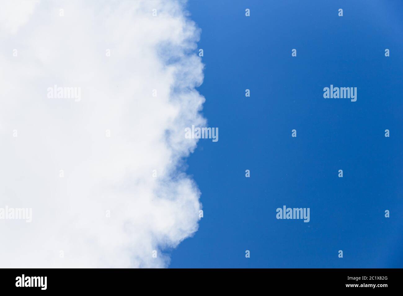 Sky background with big white cloud. Half of the blue sky, half white ...