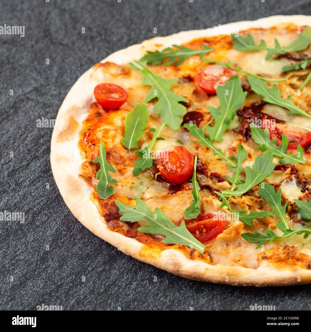 Juicy pizza on the table with cherry tomatoes and ruccola Stock Photo ...