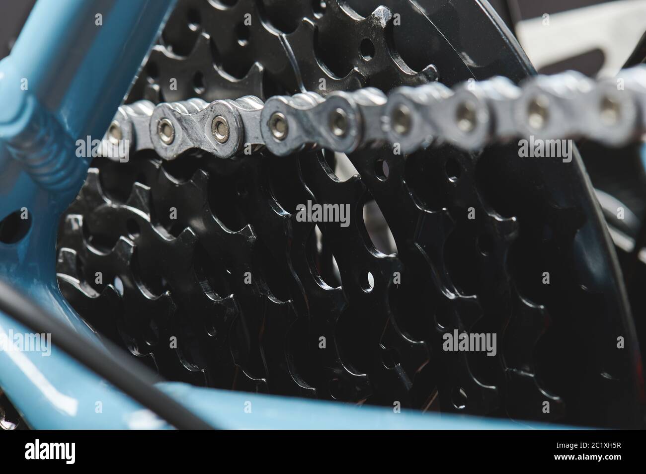 Metal bicycle chain on black gear system background Stock Photo - Alamy