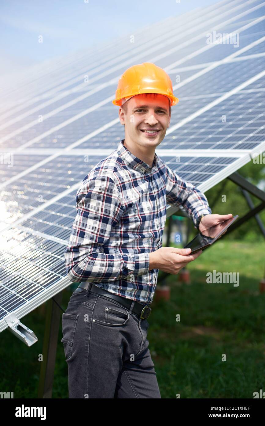 Vertical portrait of engineer in helmet with tablet in his hands ...