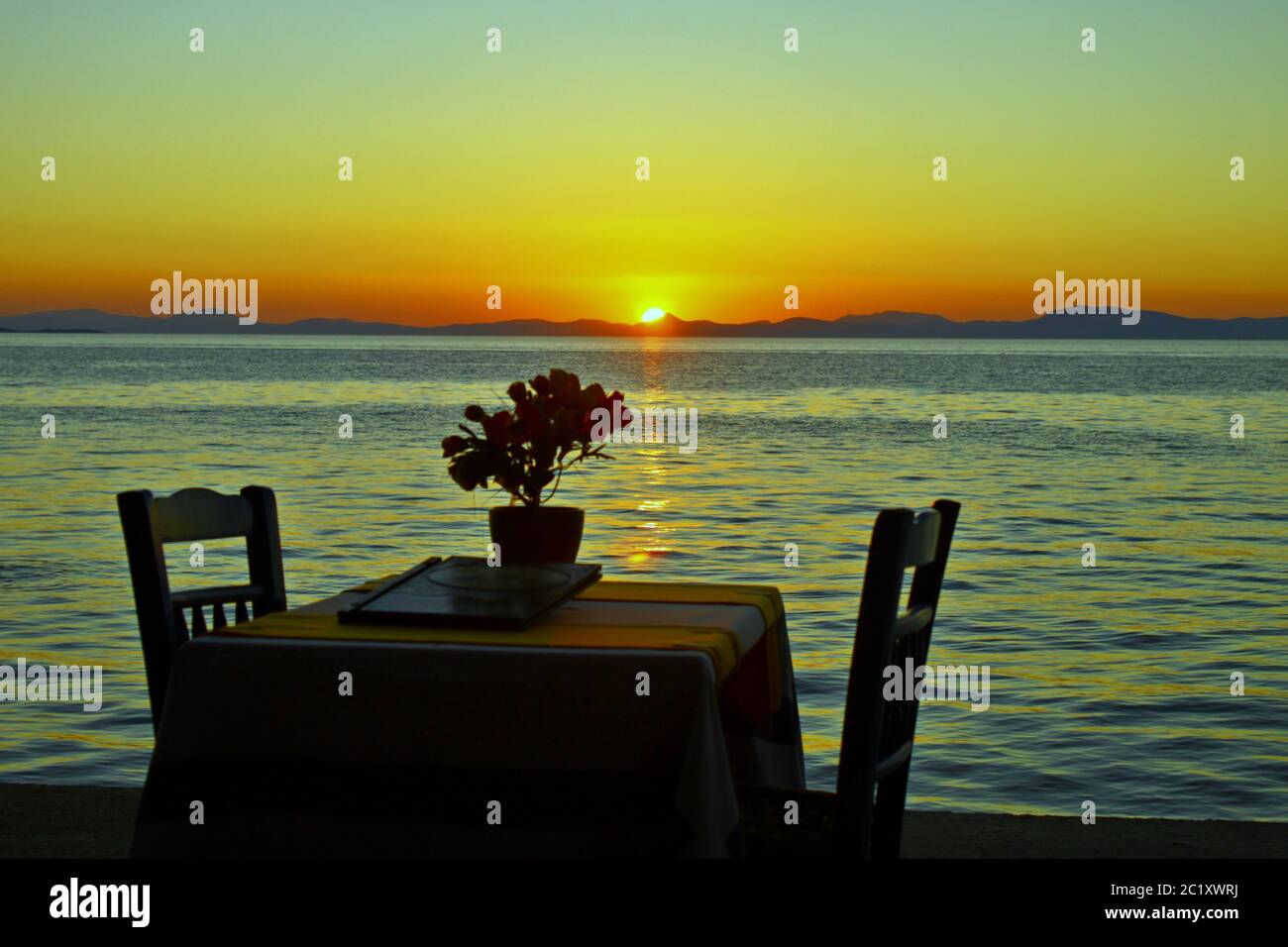 Couple sitting table beach sunset hi-res stock photography and images ...