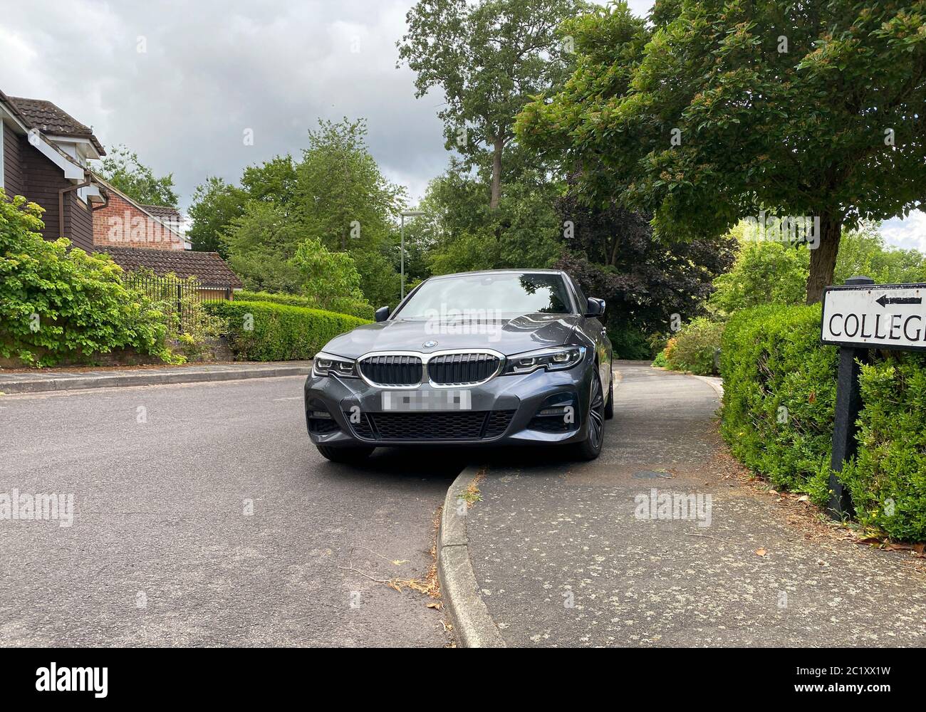 A car parked on a pavement in Surrey, England. The blocking of ...