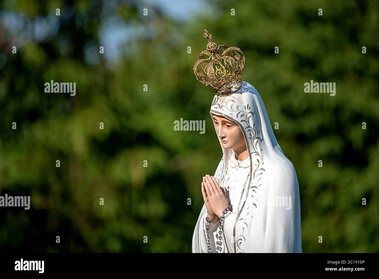 The figure of the Virgin Mary in the crown with a rosary in her hands ...
