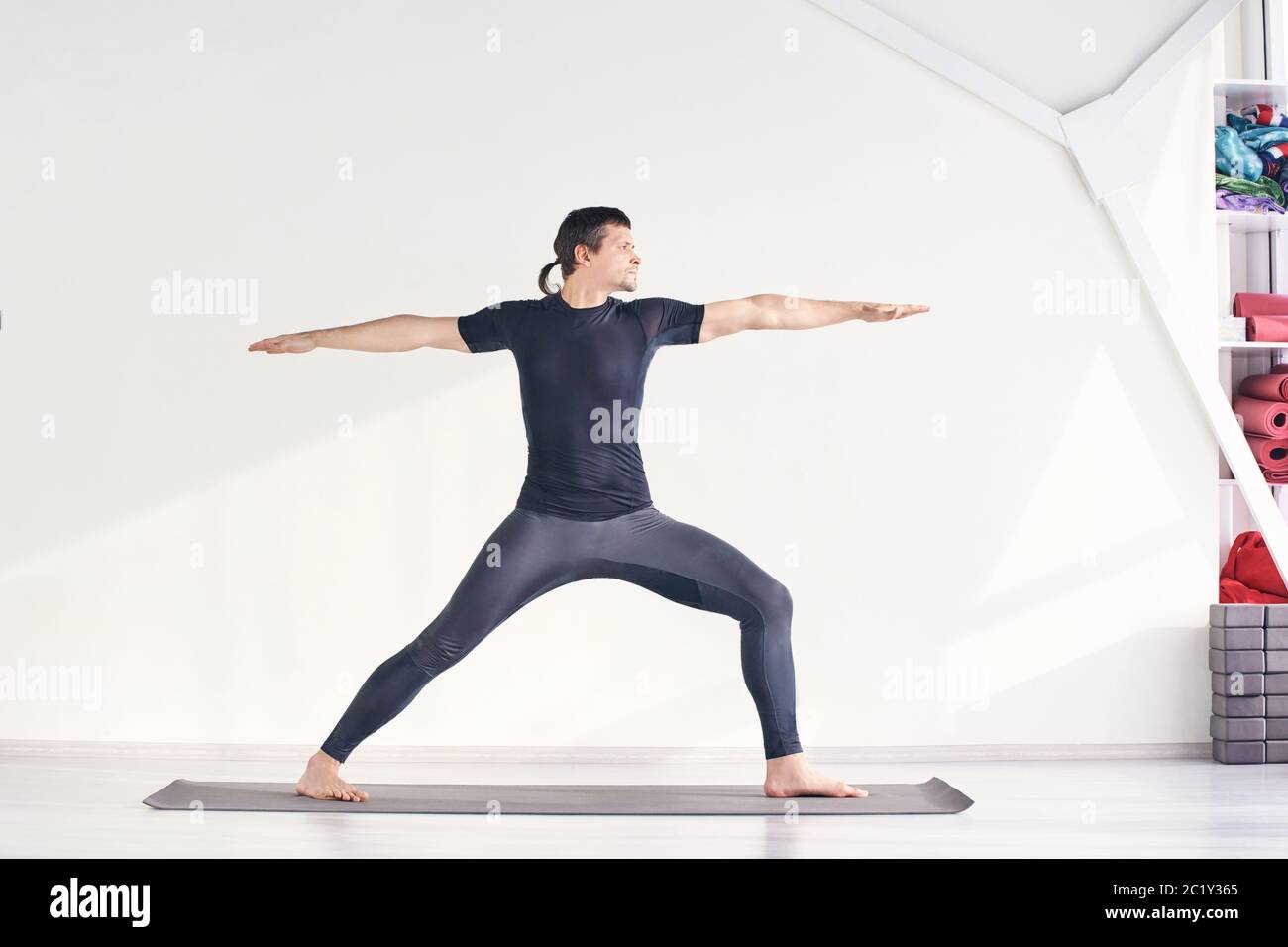 Man stand at warrior pose. Yoga exercise Stock Photo - Alamy