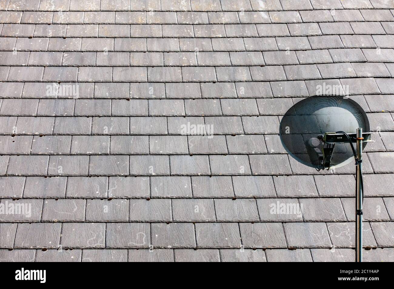 TV and media satellite dish on a tiled house roof from above Stock ...