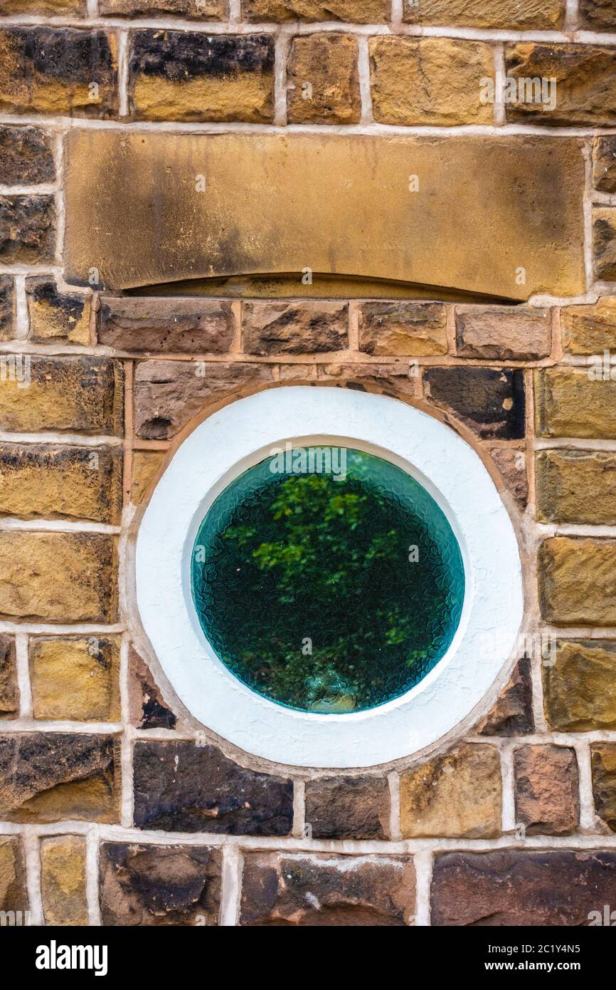 Round cottage window on stone house wall Stock Photo - Alamy
