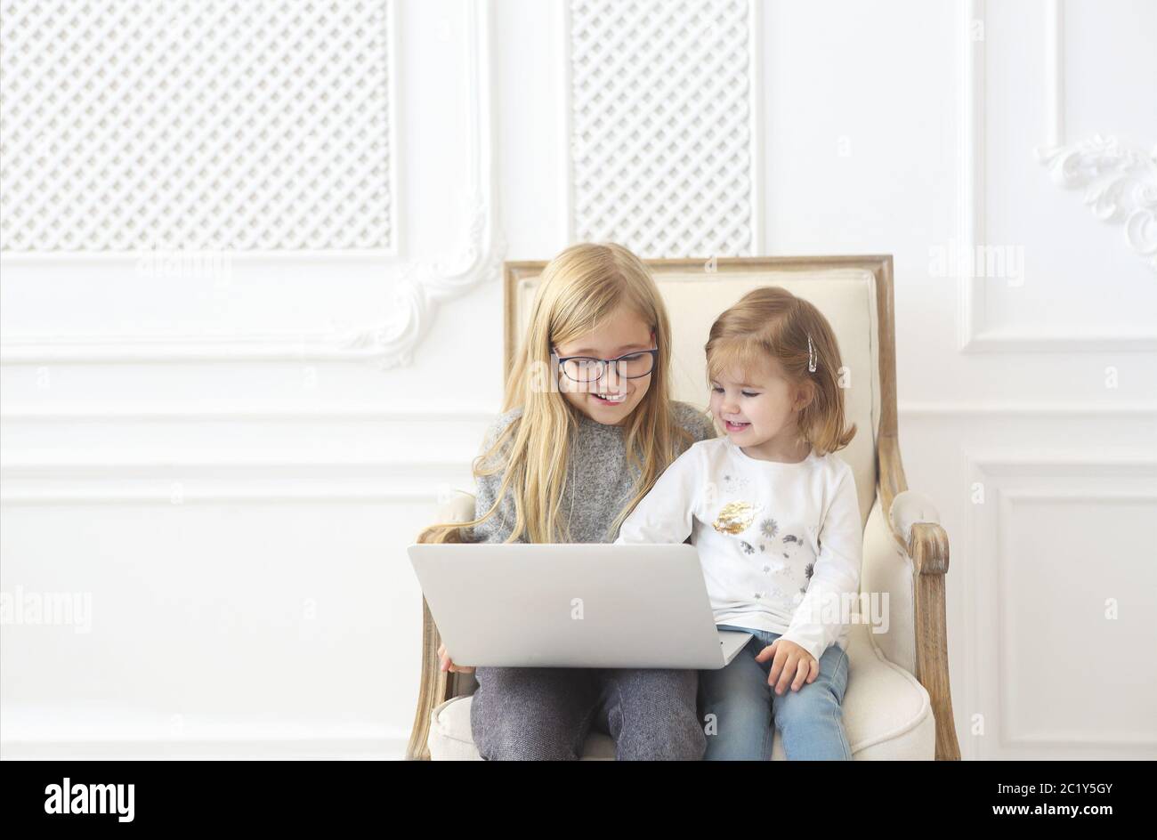 Two adorable litle sisters using their computer laptop together Stock ...