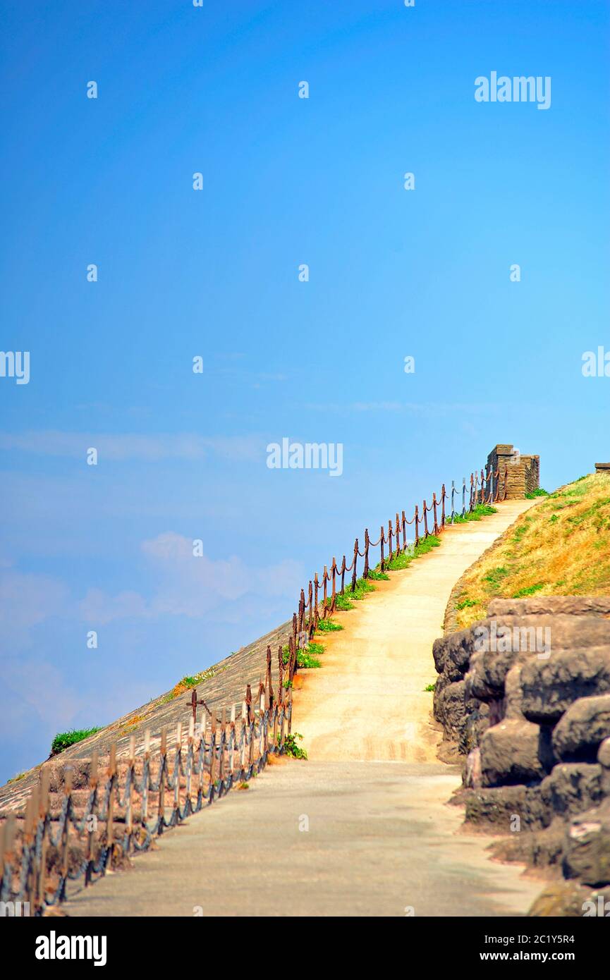 Steep cliff side path with chain link fence against the sky Stock Photo ...