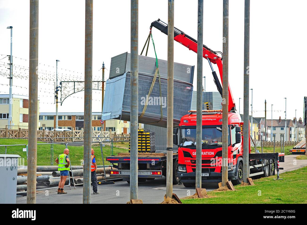 Two workmen unloading fences off a lorry in preparation for Blackpool ...