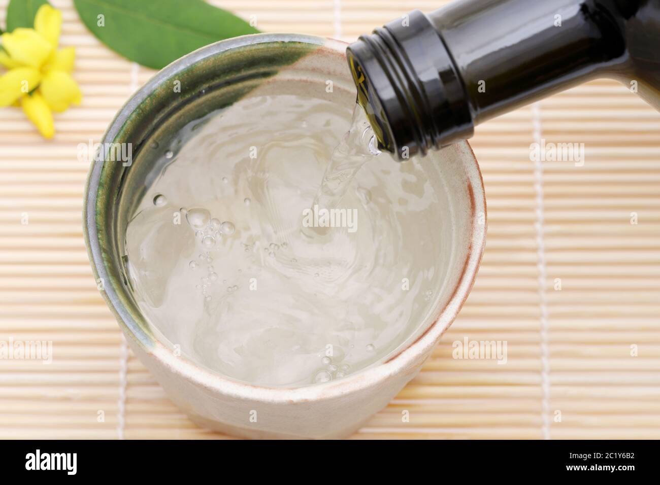 Bottle of Japanese shochu and ceramic bowl on bamboo table Stock Photo ...