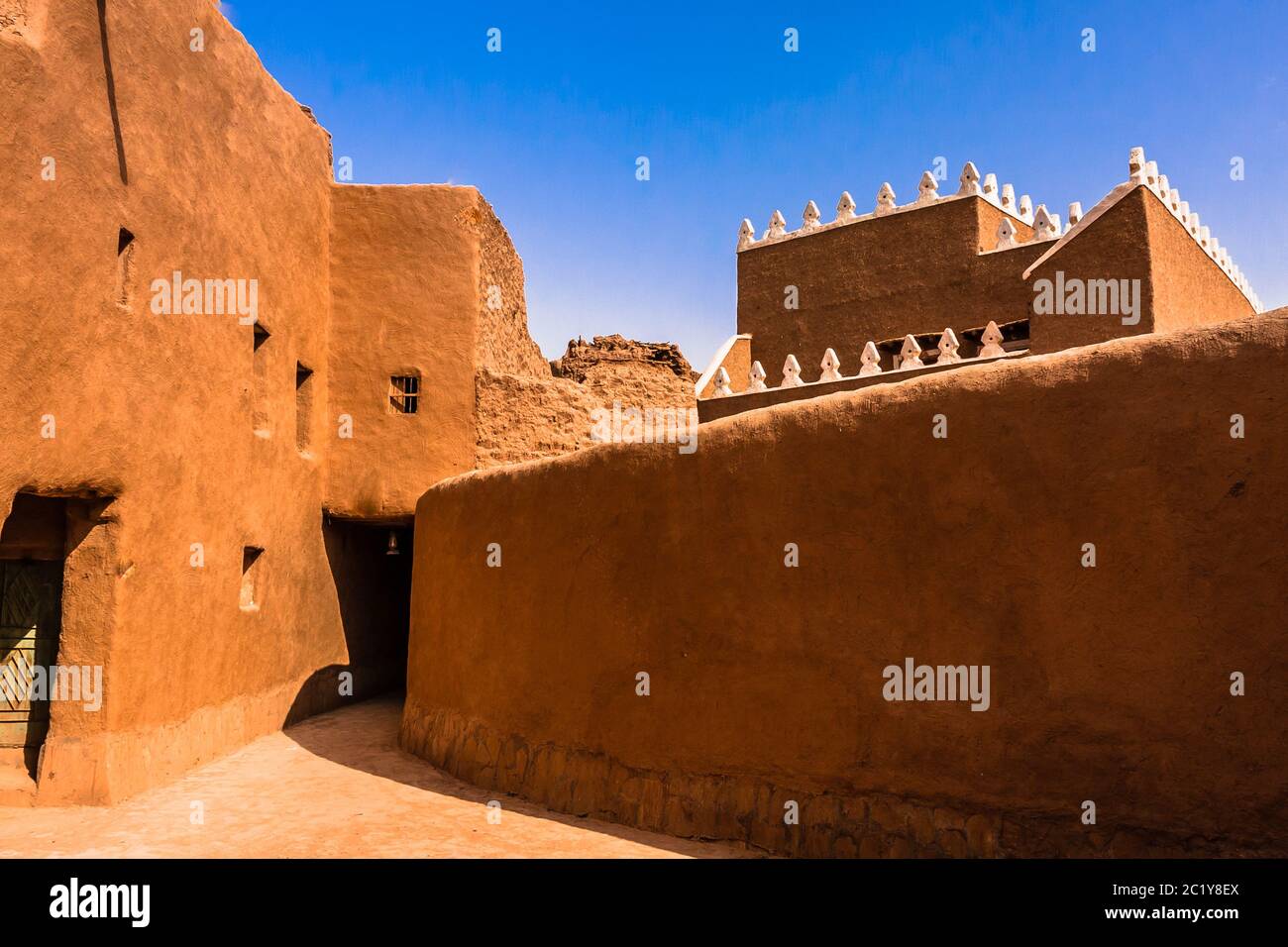 A narrow street in a traditional Arab mud brick village, Al Majmaah ...