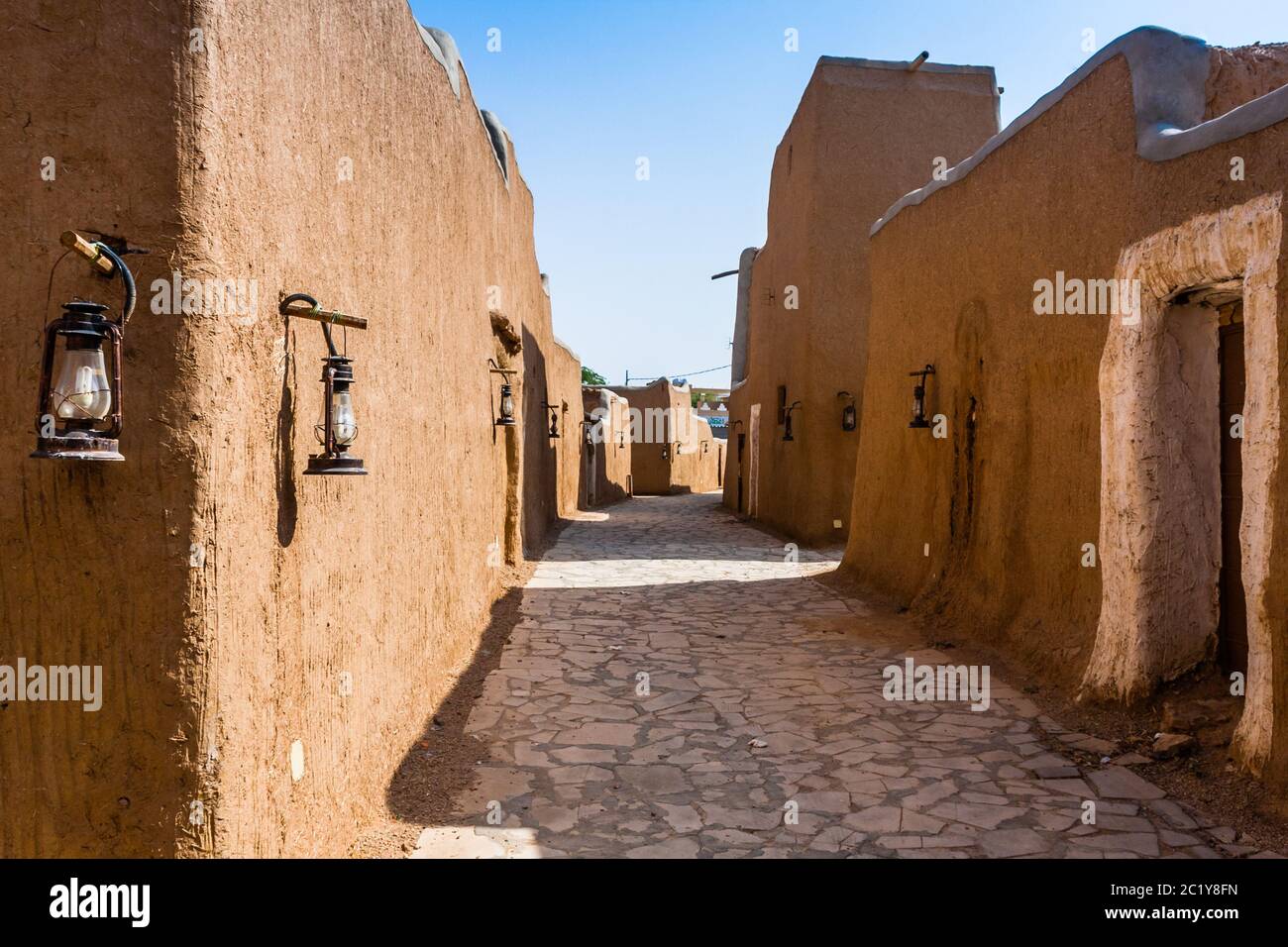 A narrow street in a traditional Arab mud brick village, Al Majmaah ...
