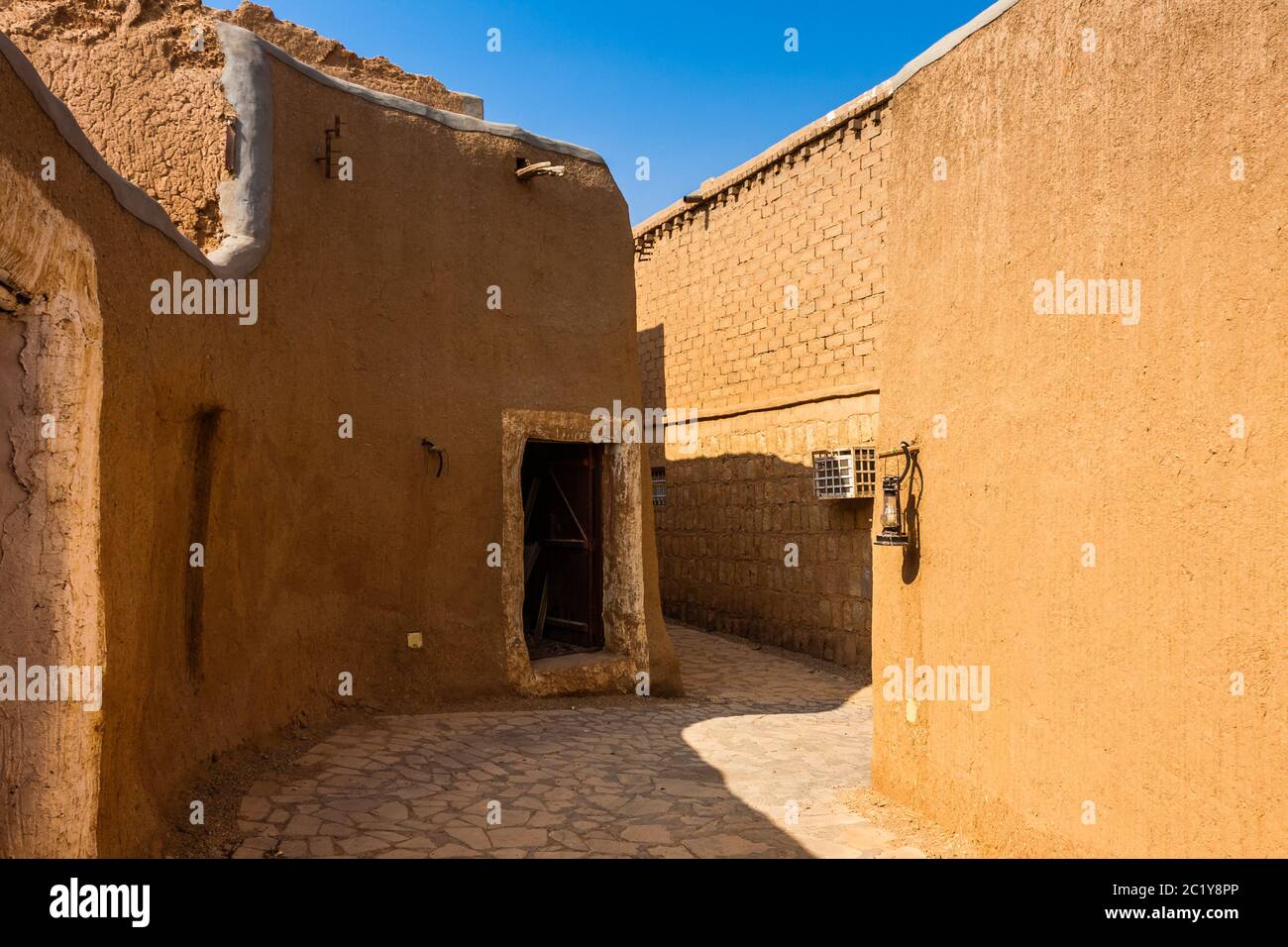 A narrow street in a traditional Arab mud brick village, Al Majmaah ...