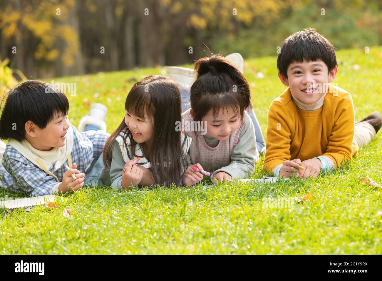 Lovely children lay on the grass to paint Stock Photo - Alamy