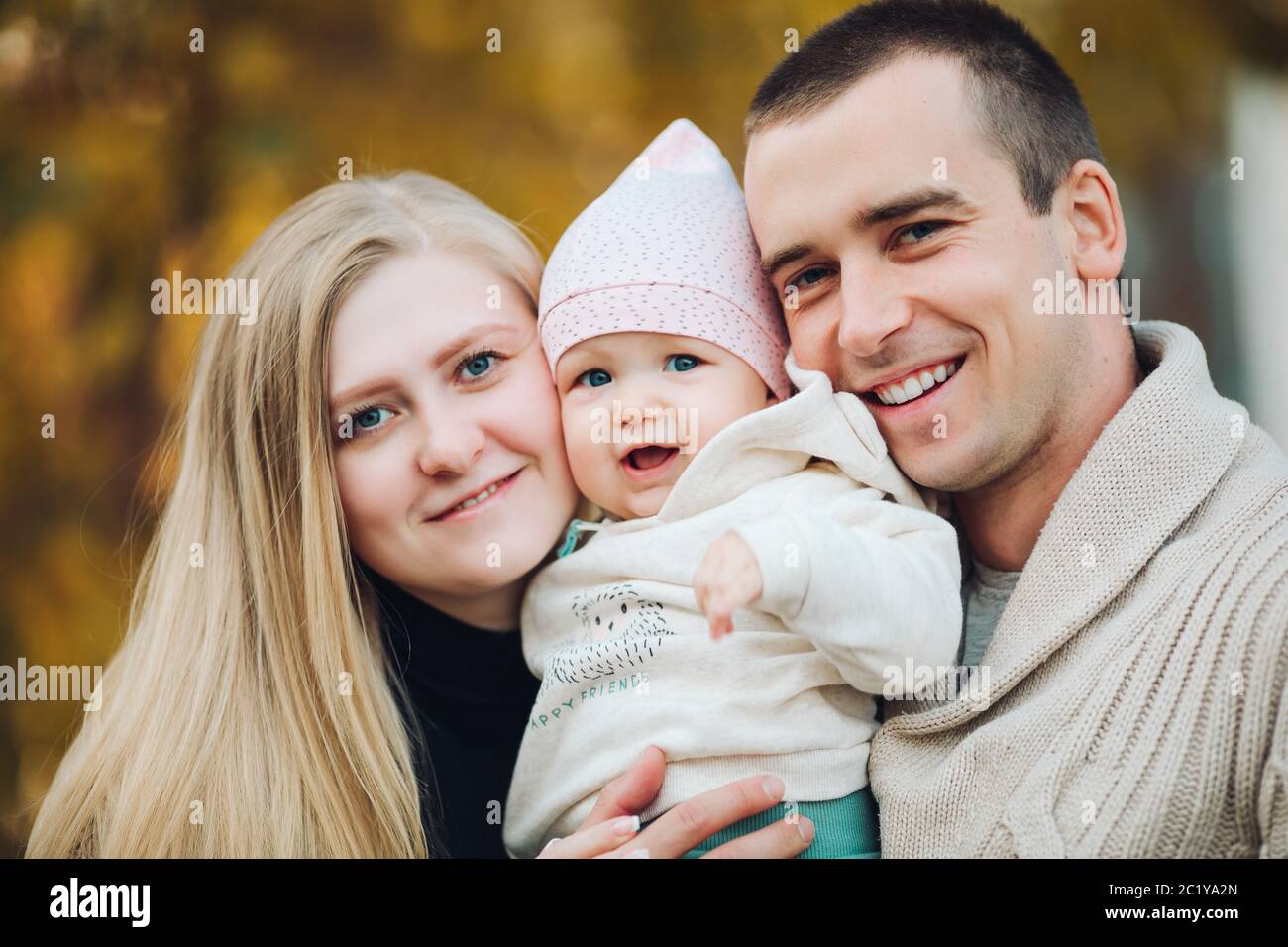 Young happy family smiling at camera and standing together Stock Photo ...
