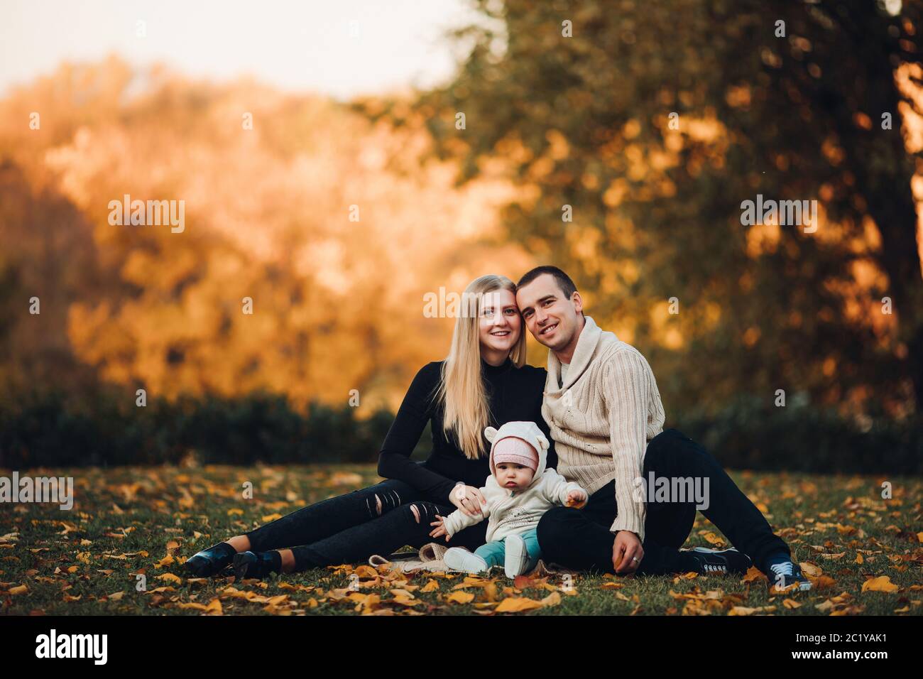 Young happy family smiling at camera and standing together Stock Photo ...