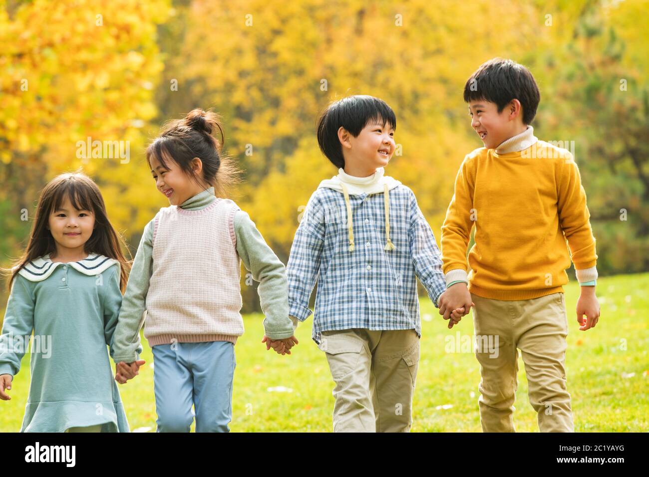 Happy children hand in hand walk in the park Stock Photo - Alamy