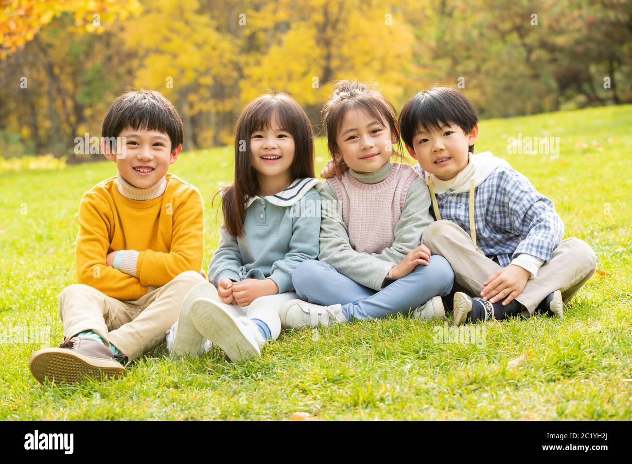 Children sitting on the grass hi-res stock photography and images - Alamy