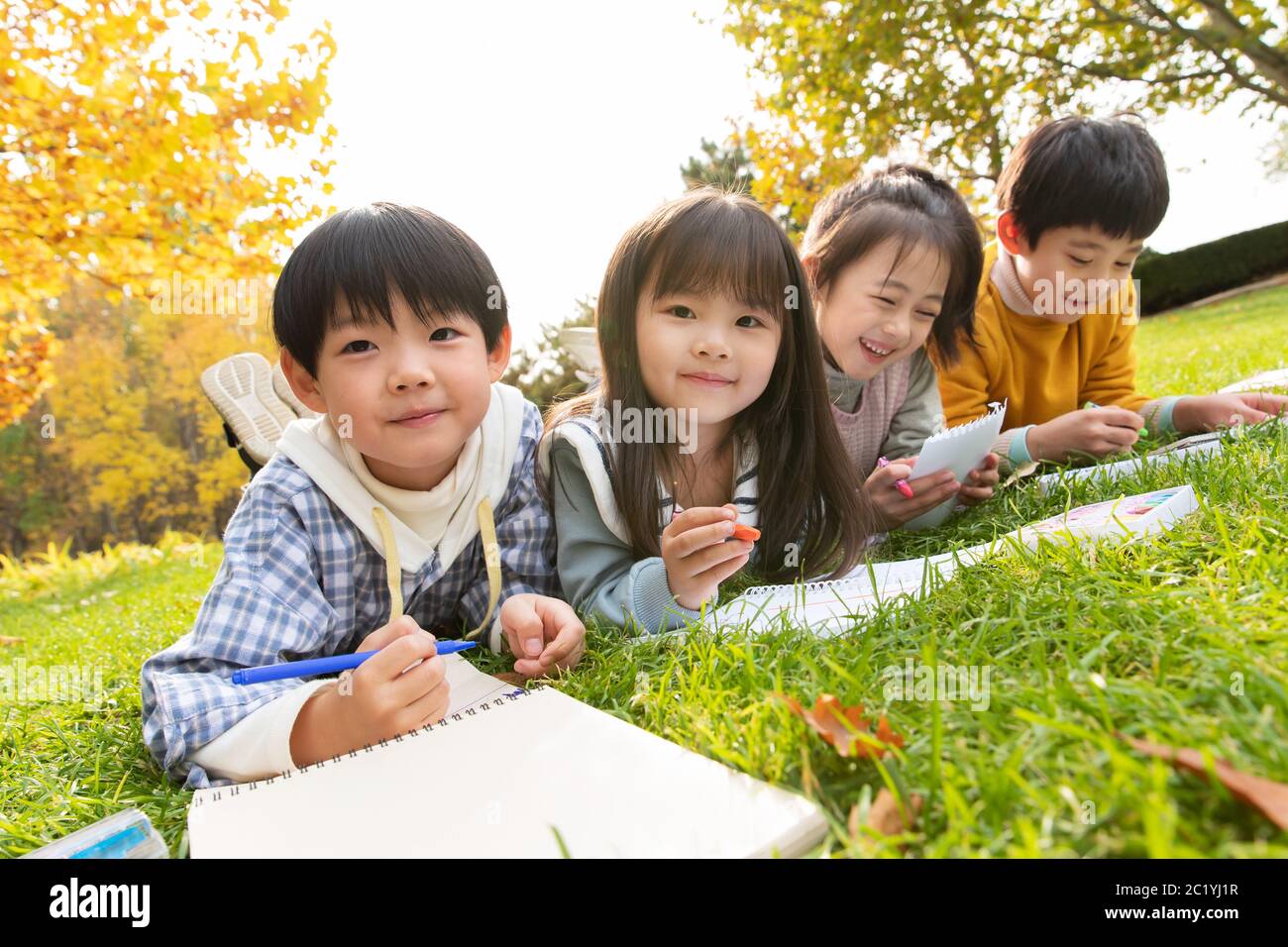 Lovely children lay on the grass to paint Stock Photo - Alamy